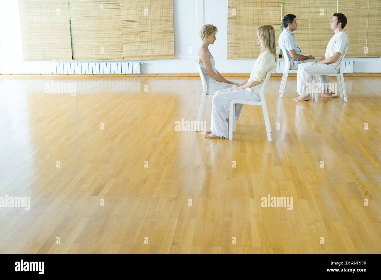 Two pairs of adults sitting together during therapy session Stock Photo ...