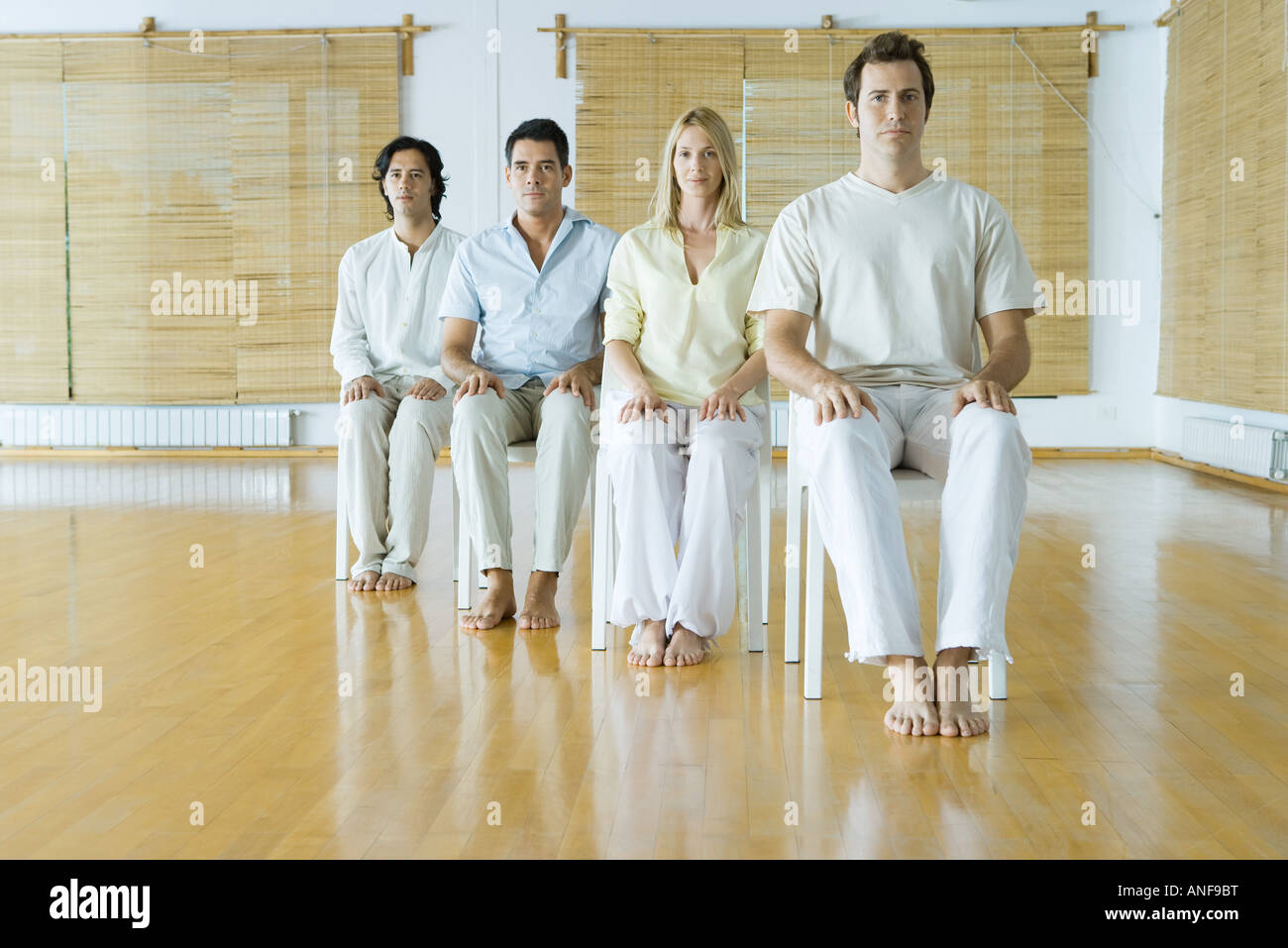 Four adults sitting in chairs in wellness center, facing camera Stock ...