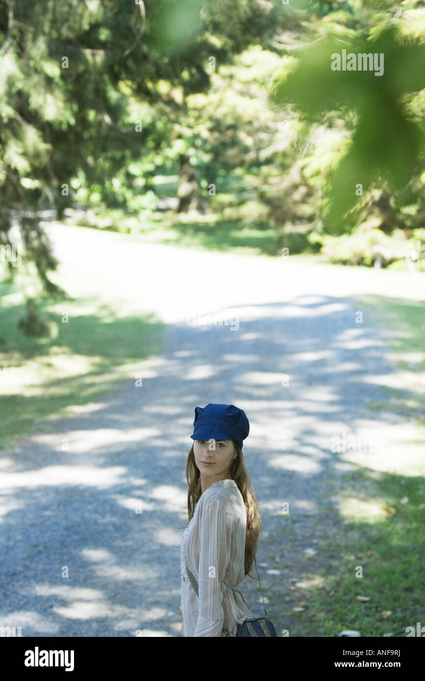 Young woman in park, wearing cap, looking up at camera Stock Photo - Alamy