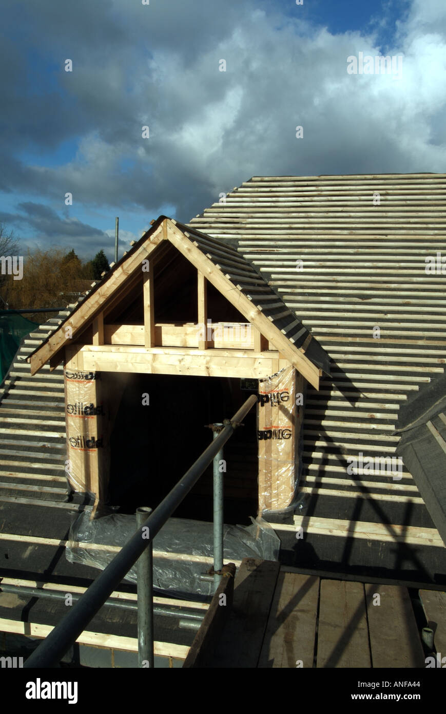 Detached house under construction roof works including gable end felt ...