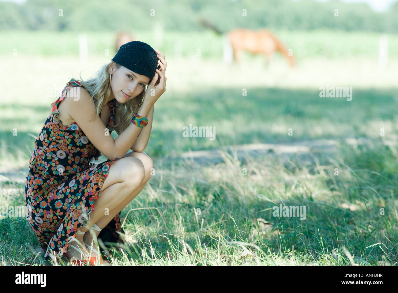 Woman crouching on grass looking up hi-res stock photography and images ...