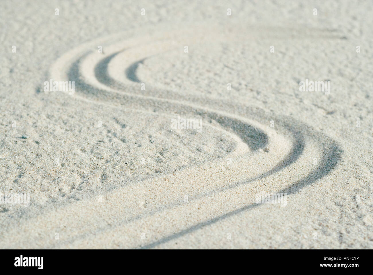 Curve pattern traced into sand Stock Photo - Alamy