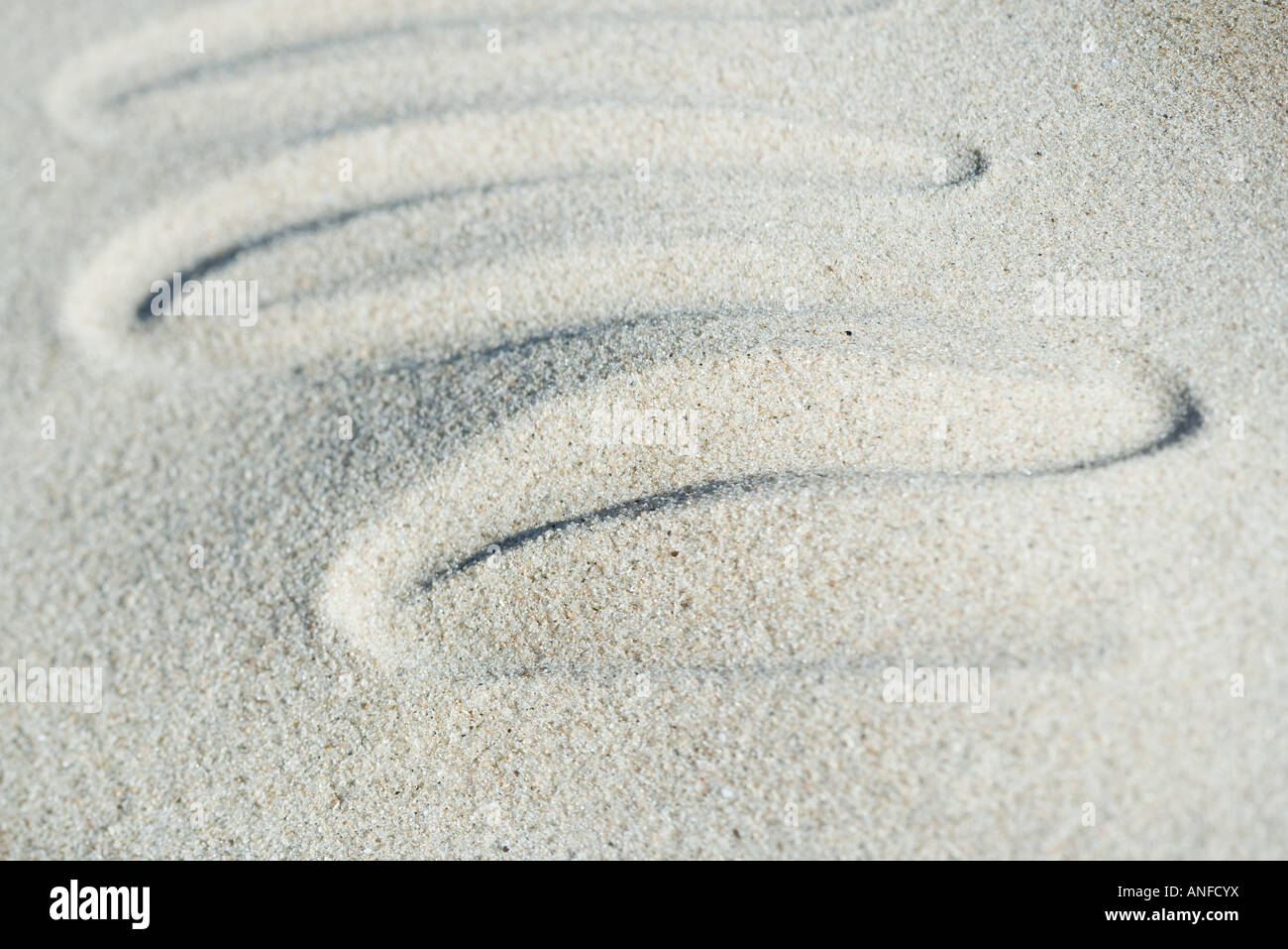 Squiggly pattern drawn in sand Stock Photo - Alamy
