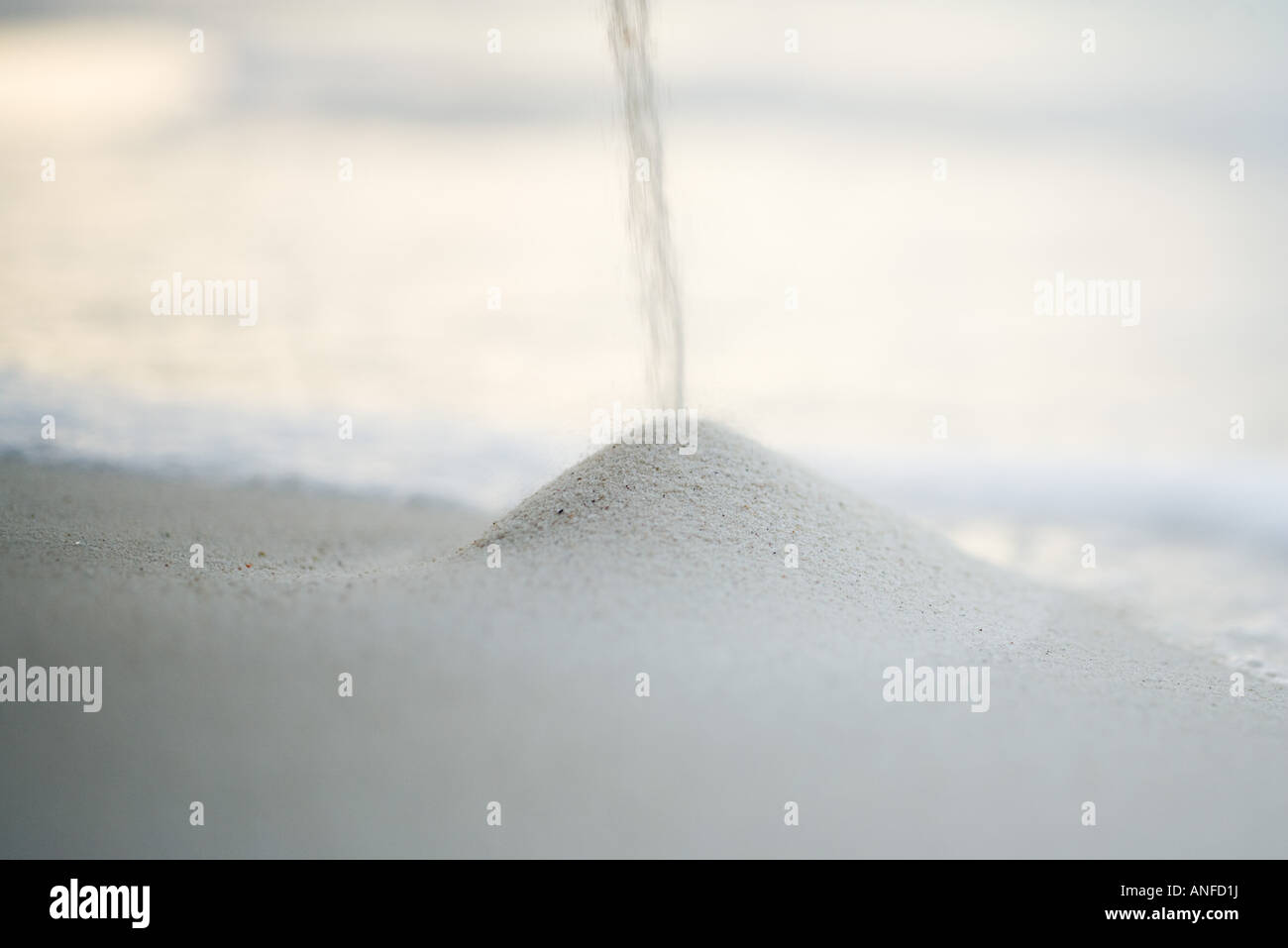 Sand falling onto pile on beach Stock Photo - Alamy