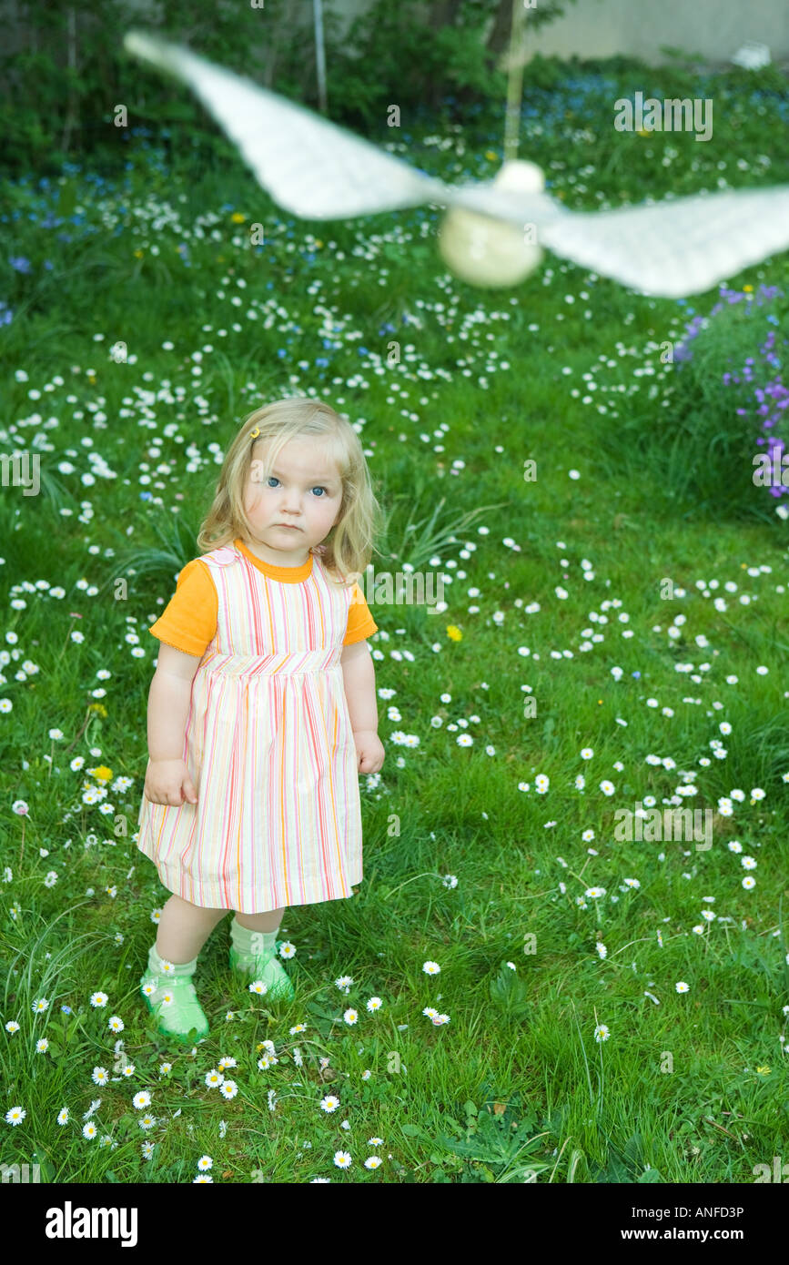 Little girl watching fake bird hanging from string Stock Photo - Alamy