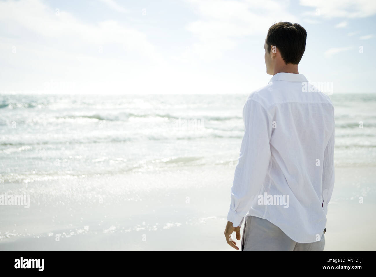 Man looking at ocean, rear view Stock Photo - Alamy