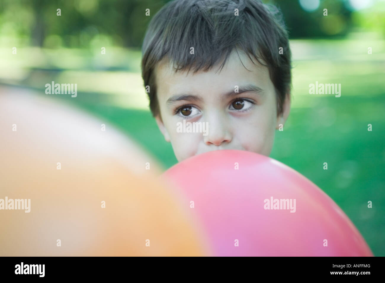 Boy blowing up balloon Stock Photo - Alamy