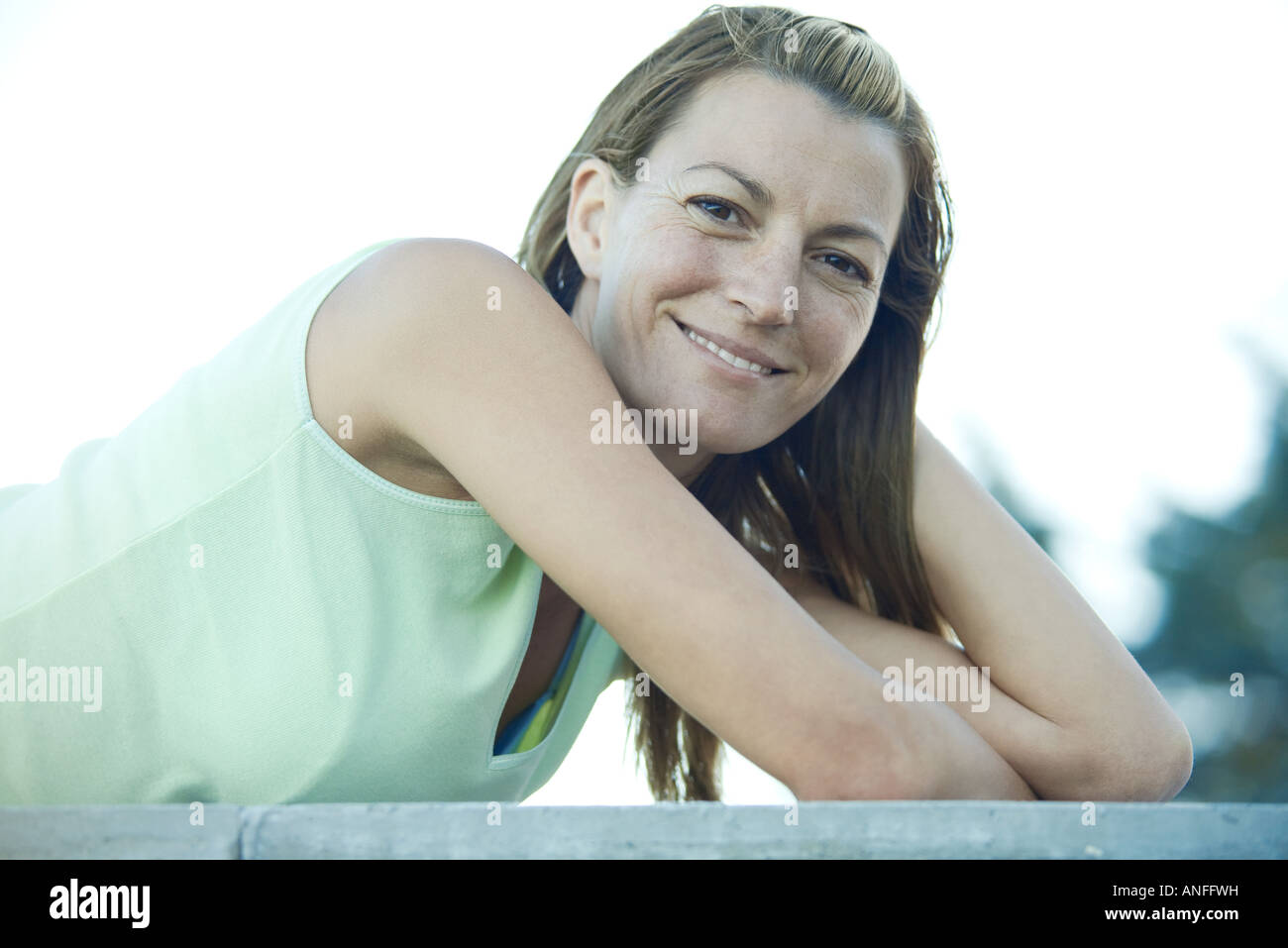 Woman leaning on elbow, smiling at camera Stock Photo - Alamy
