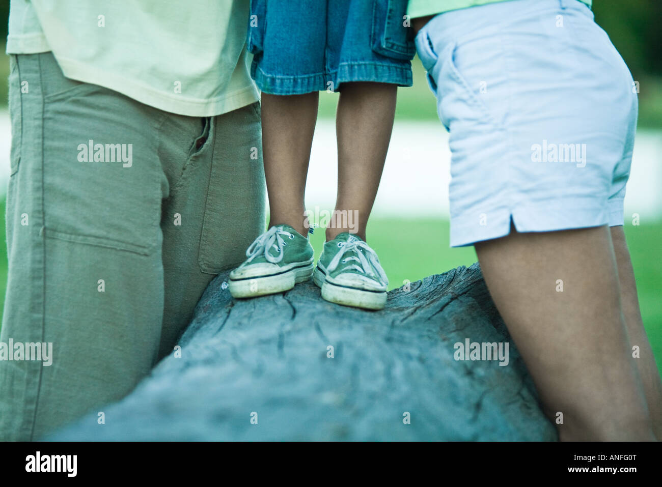 Boy standing between parents, cropped low section Stock Photo - Alamy