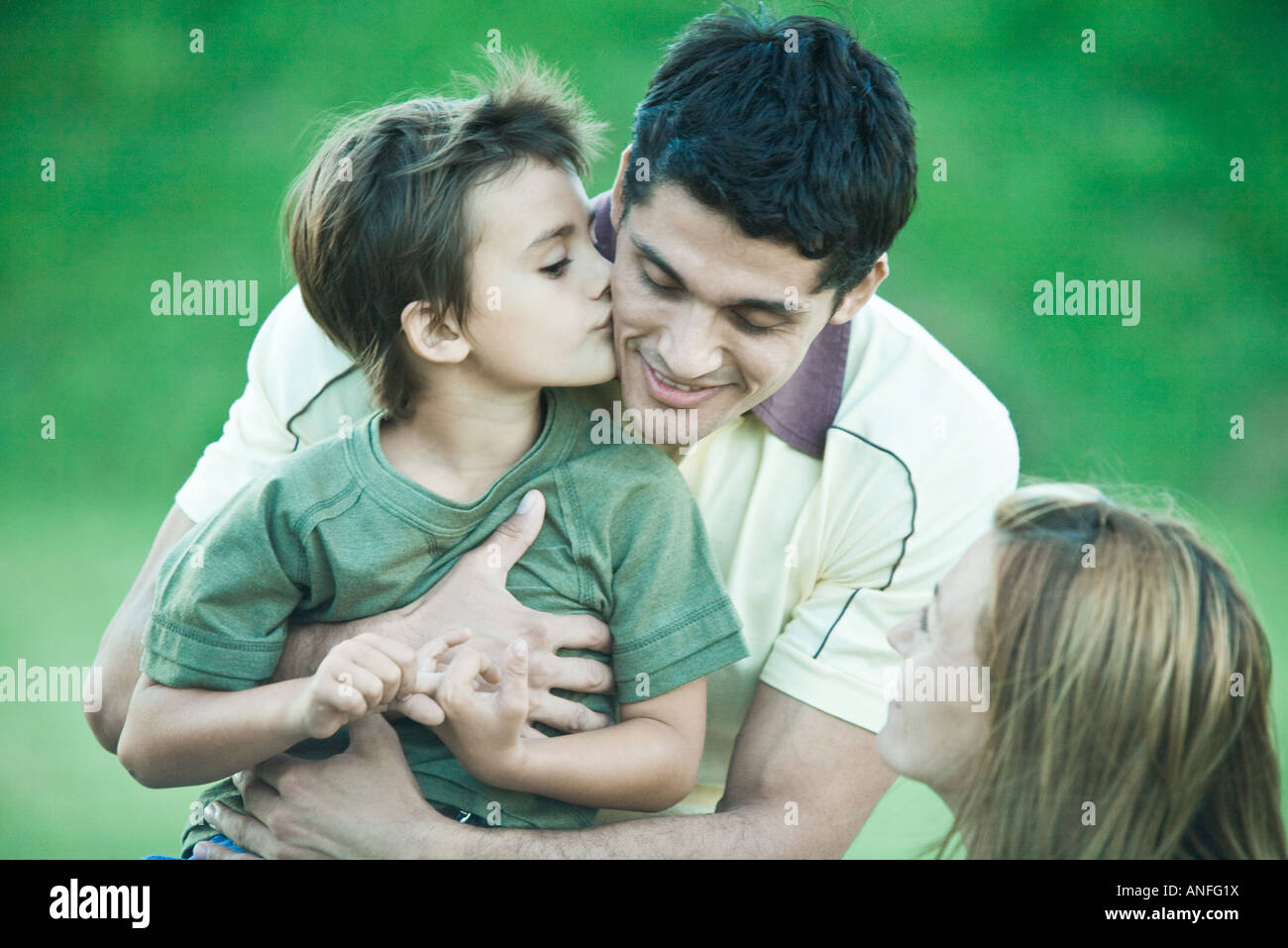 Boy with parents, kissing father on cheek Stock Photo - Alamy