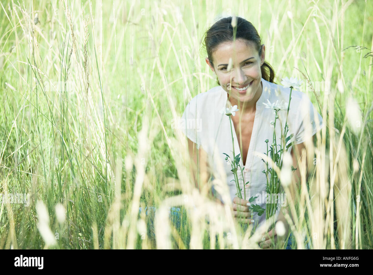 Woman in field, smiling at camera Stock Photo - Alamy