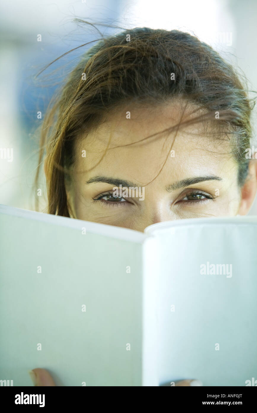 Woman looking over book Stock Photo - Alamy