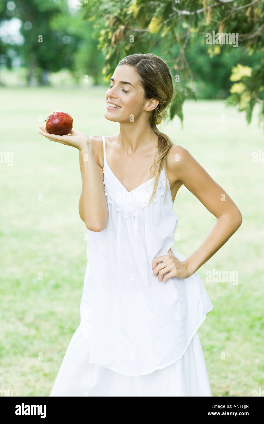 Woman balancing apple on palm of hand, smiling Stock Photo - Alamy