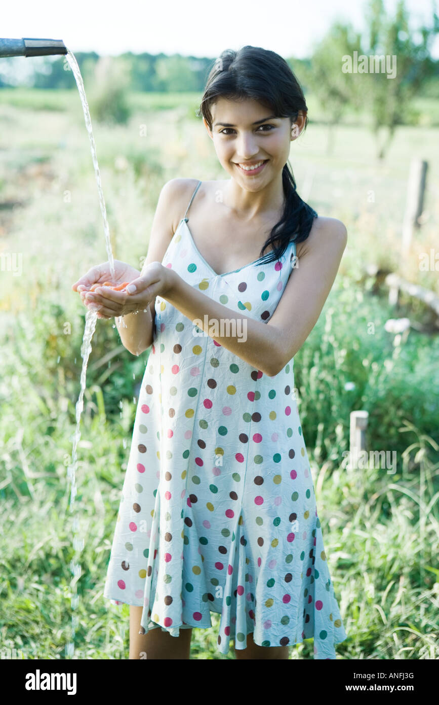 Young woman rinsing off handful of cherry tomatoes outdoors Stock Photo ...