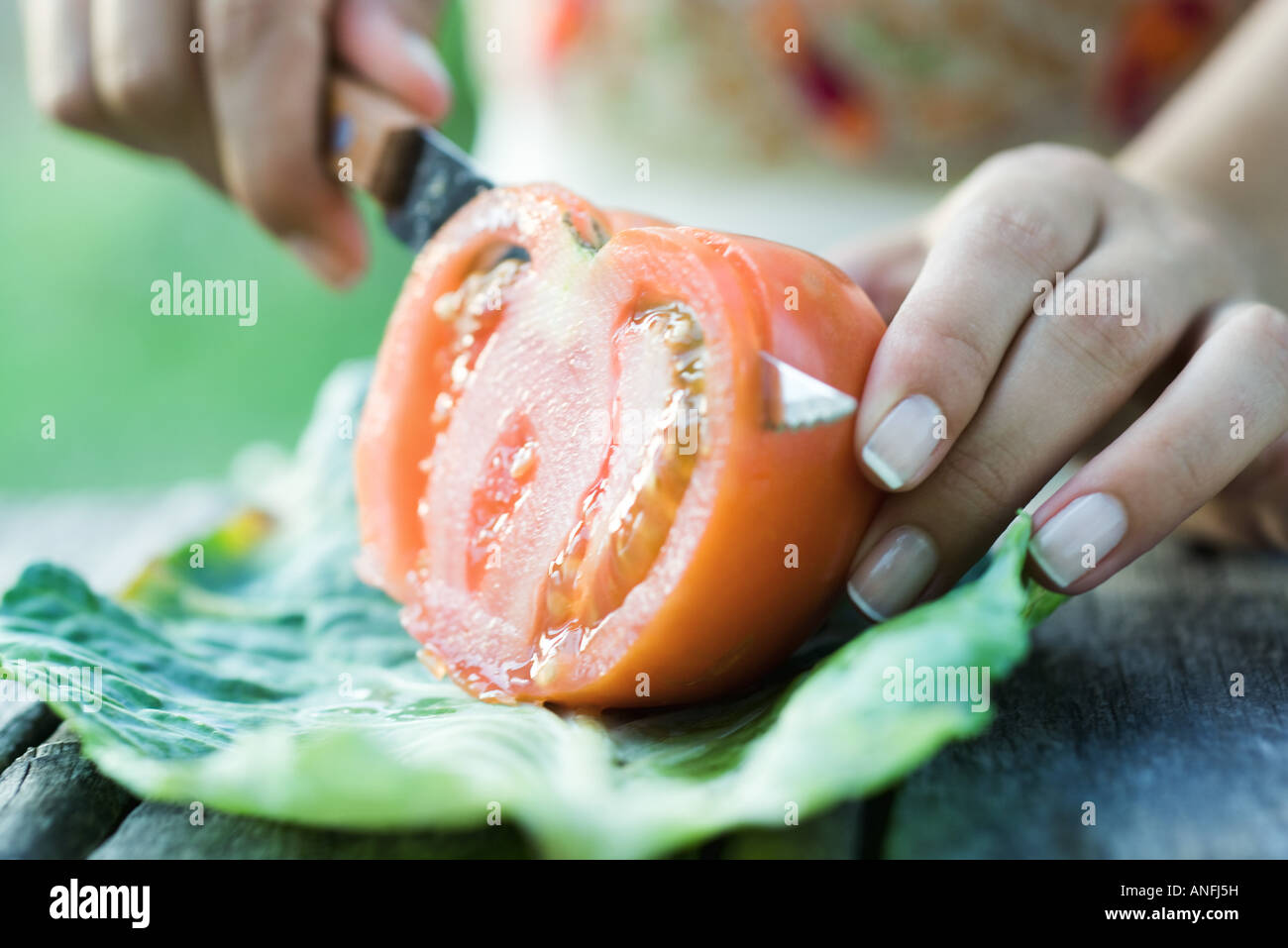 Woman slicing tomato, close-up, cropped view of hands Stock Photo - Alamy