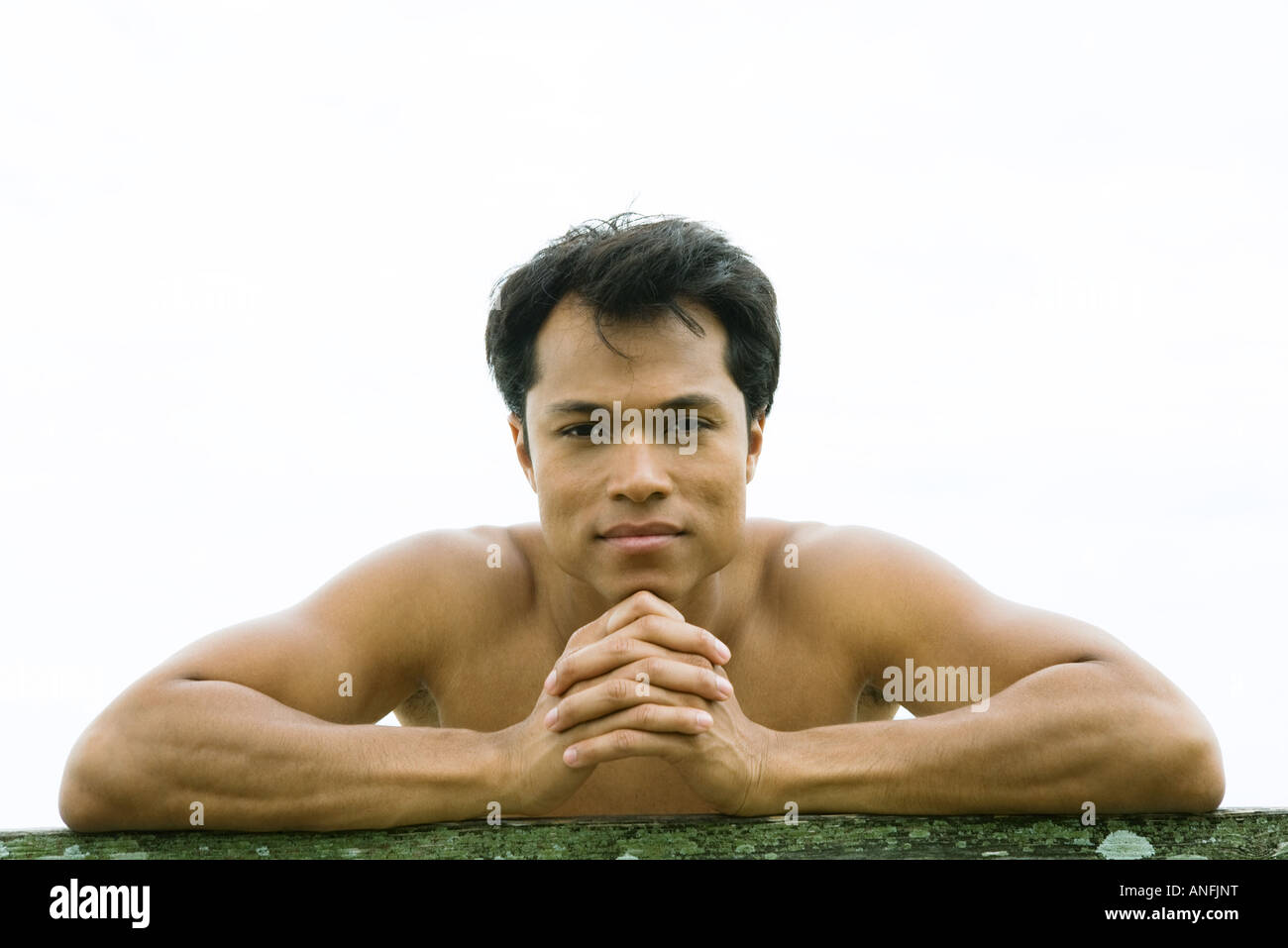 Man leaning on rail, smiling at camera Stock Photo - Alamy