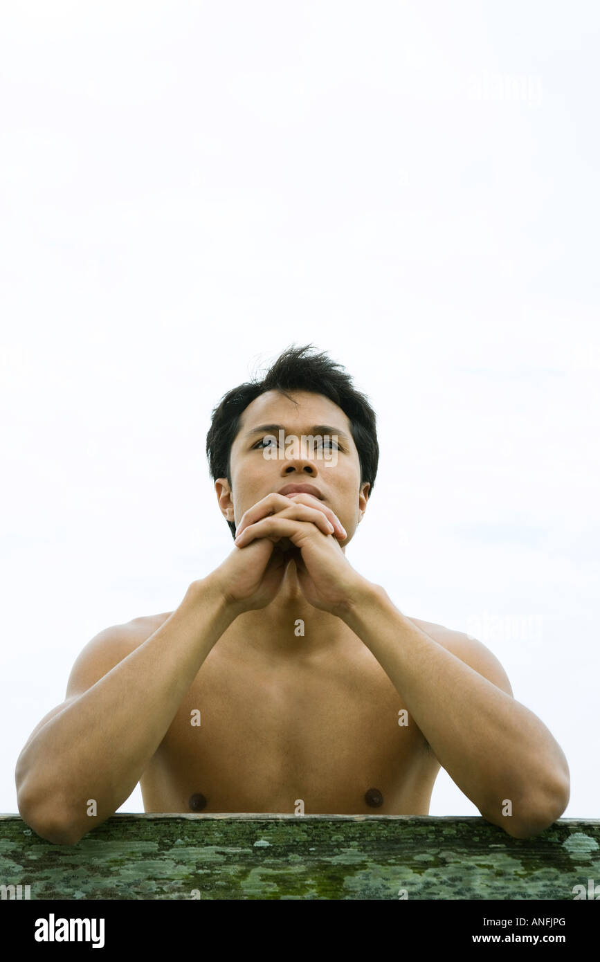Man leaning on rail, hands clasped Stock Photo - Alamy