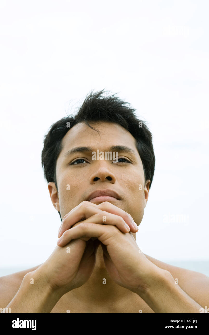 Man with hands clasped, looking up Stock Photo - Alamy