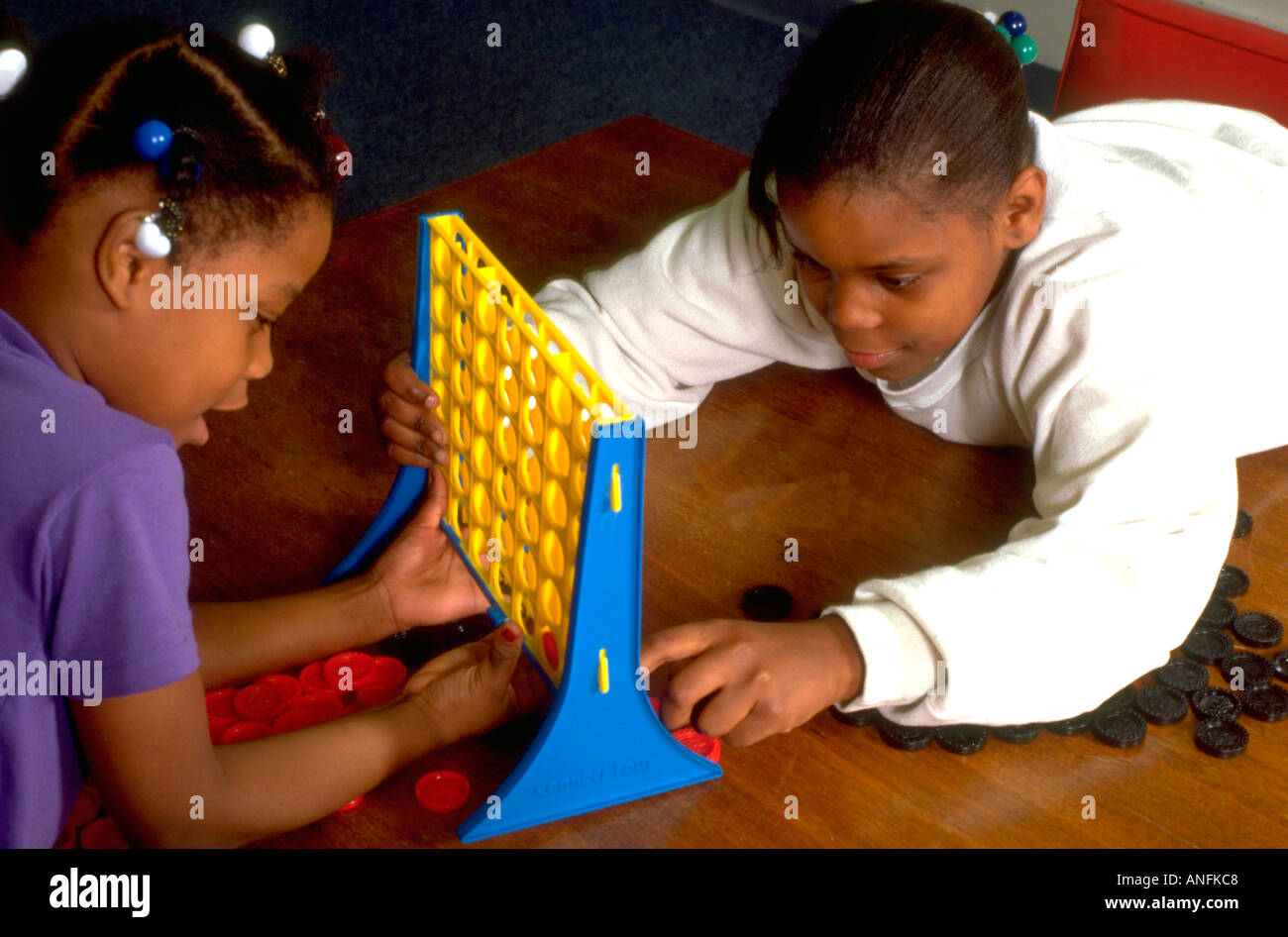 Students age 6 playing Connect Four vertical checkers game at after ...