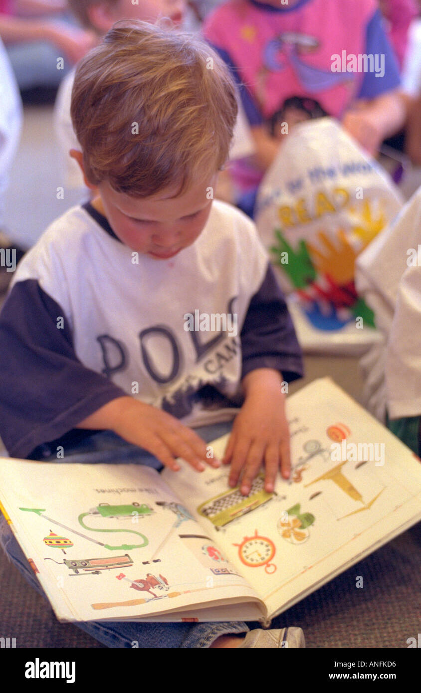 Boy age 5 reading at the public library on family day. Merriam Park ...