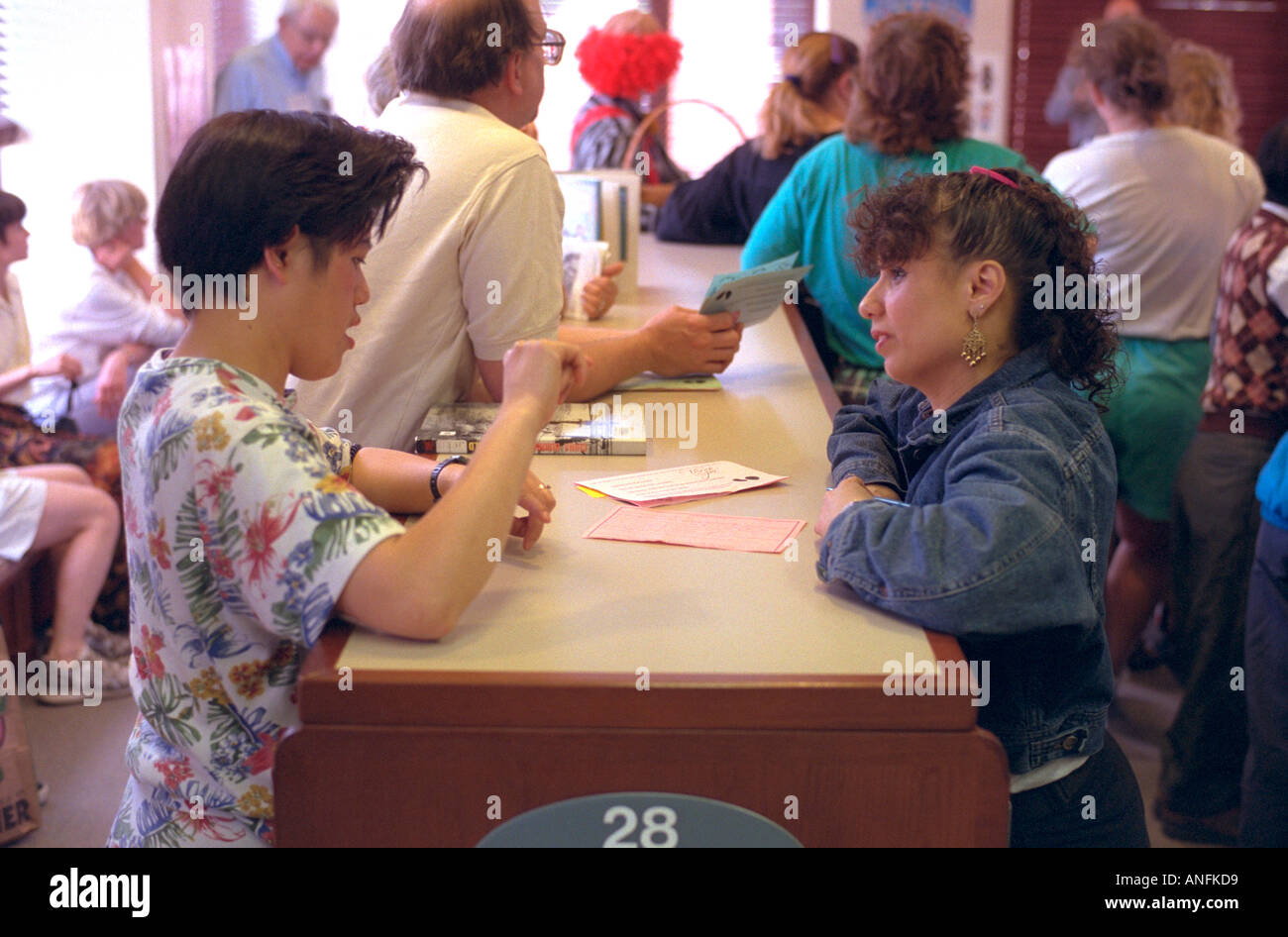 Friends age 16 conversing in sign language at public library. Merriam ...
