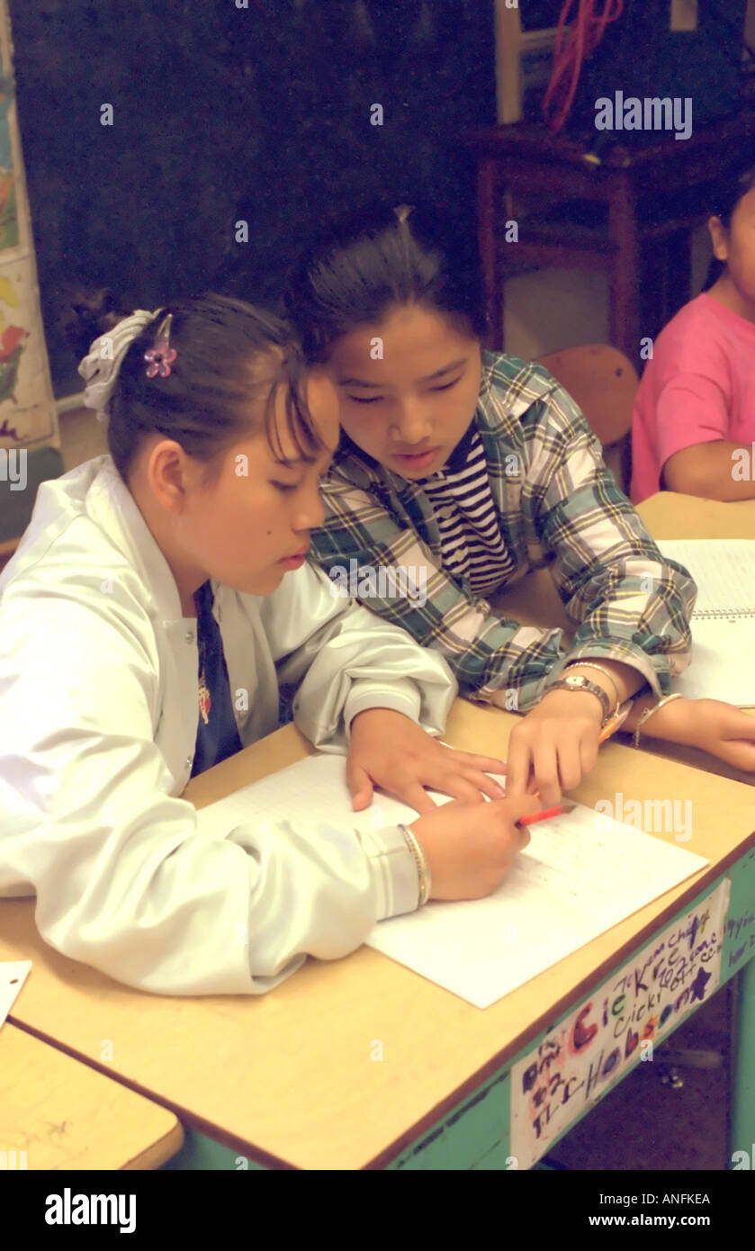 Asian American fifth graders working on homework at summer school ...