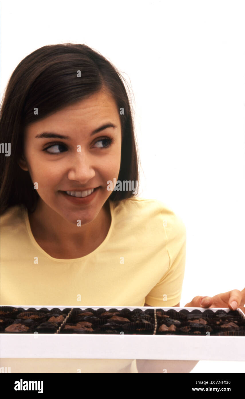 Caucasian female sneaking a piece of chocolate from a box Stock Photo ...