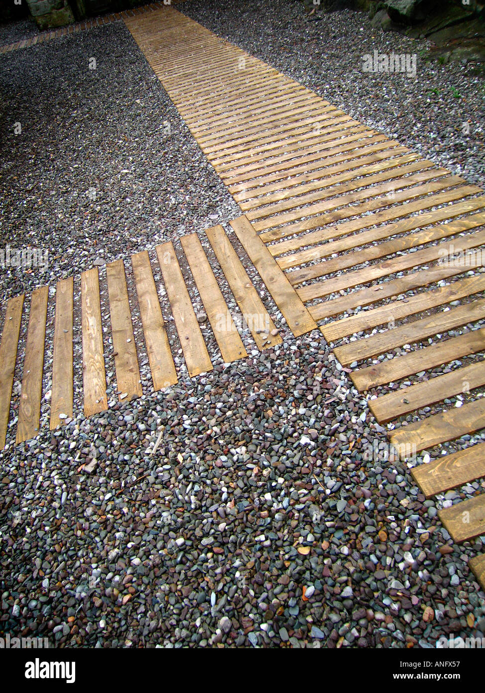 Junction in slatted wooden walkway path on gravel Stock Photo - Alamy