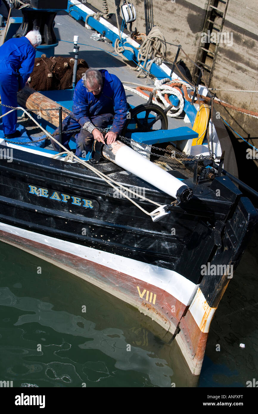 Boat workers repairing mast Stock Photo - Alamy