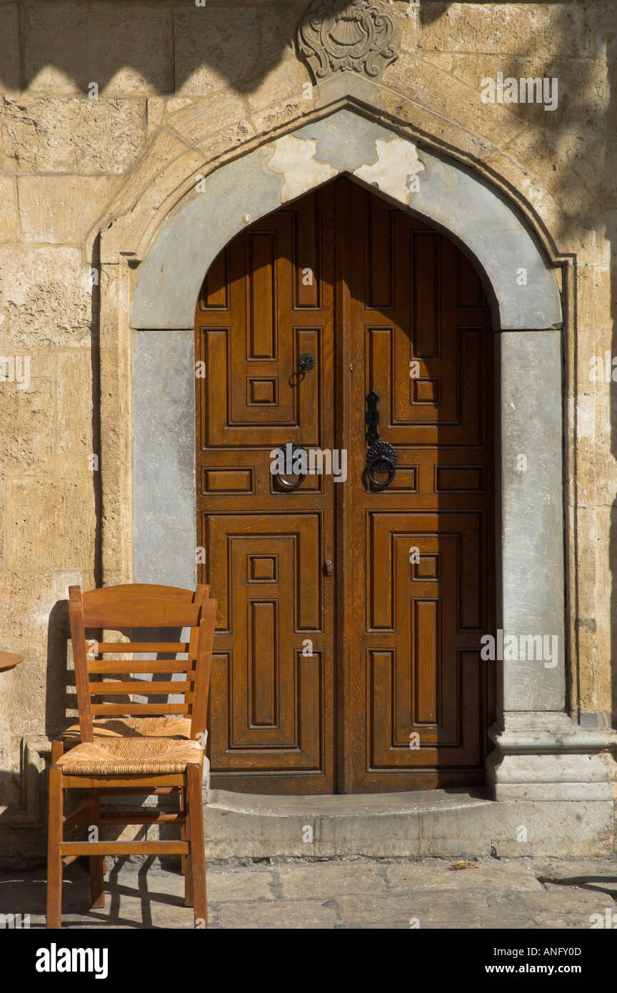 Greece Crete Iraklio wooden doors to ancient building with wooden chair ...