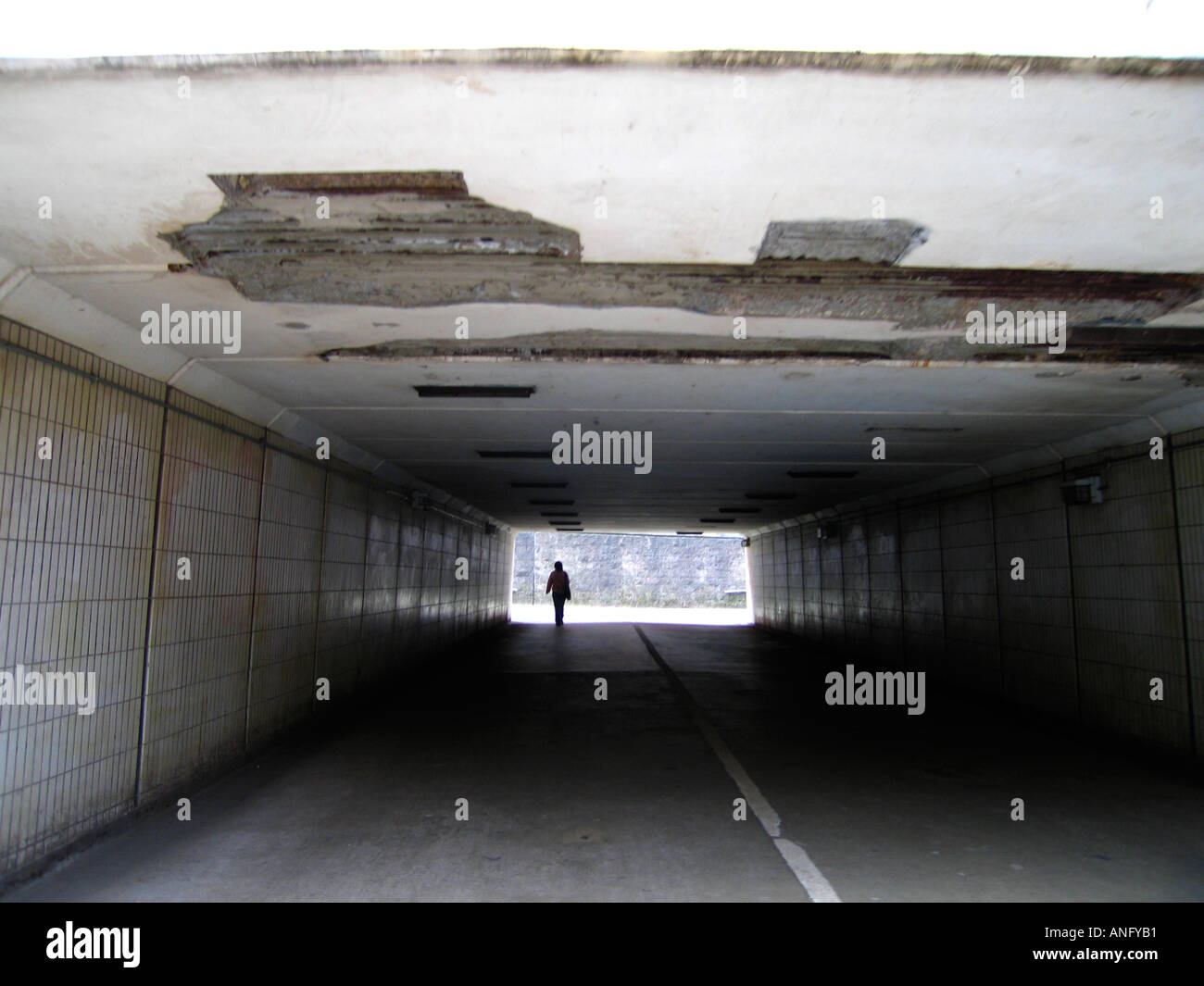 Lone pedestrian in underpass in urban city centre setting Stock Photo ...