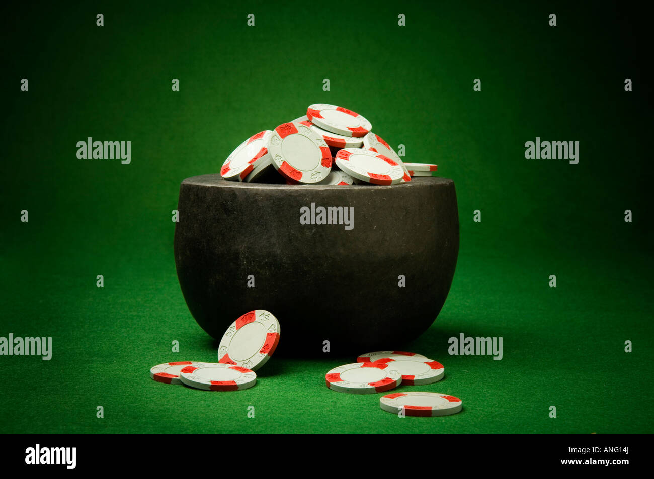pot of poker chips on a green baize background Stock Photo - Alamy