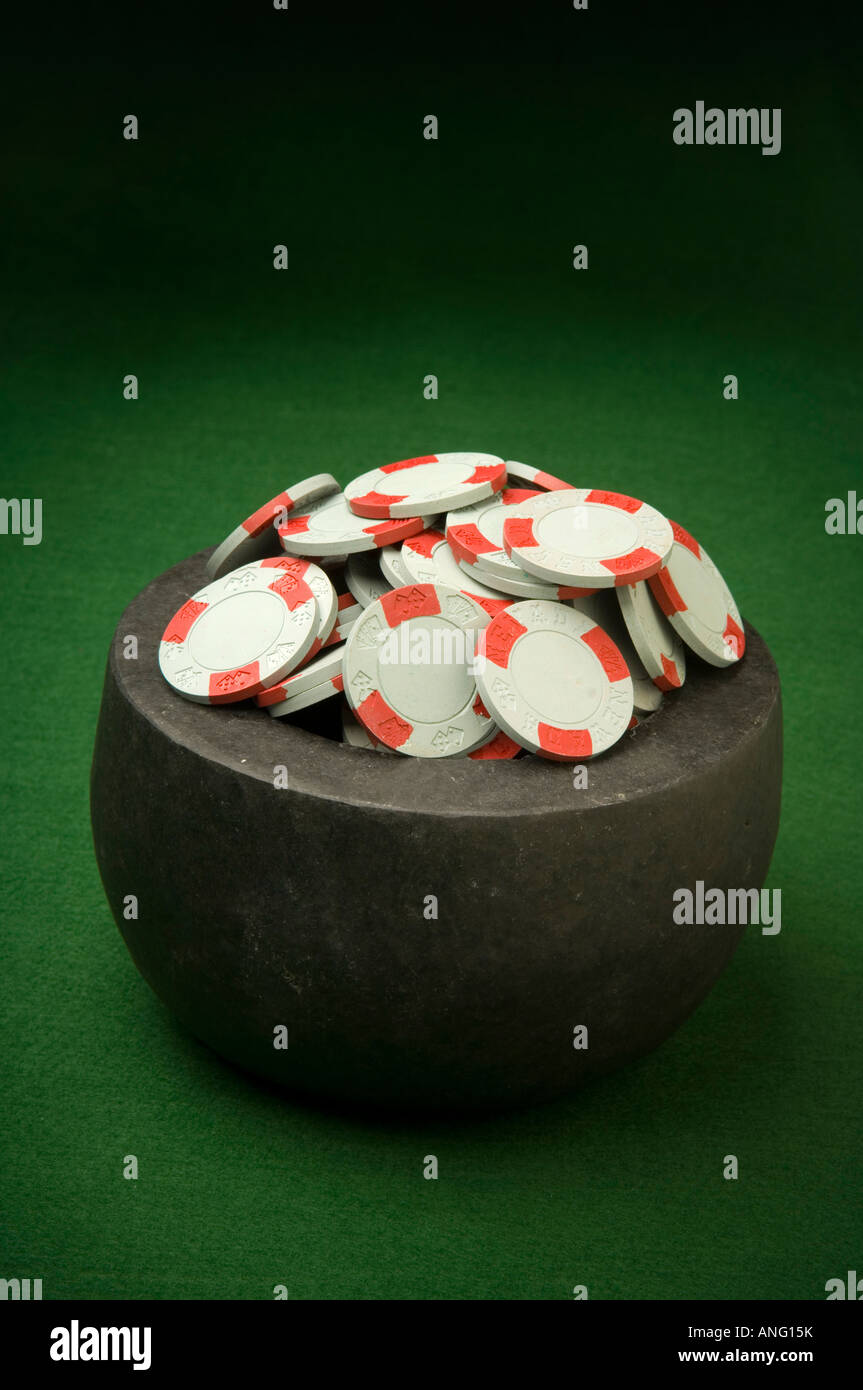 pot of poker chips on a green baize background Stock Photo - Alamy