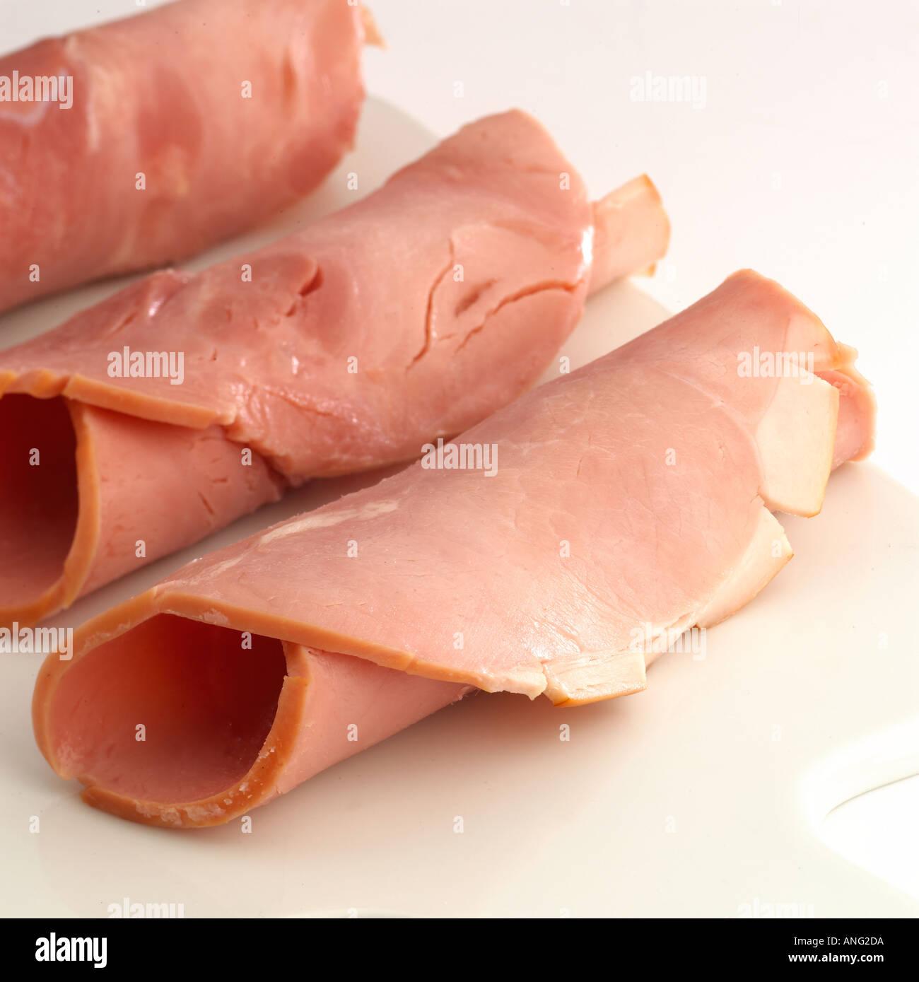 Three slices of prepacked ham rolled up on board keywords supermarket ...