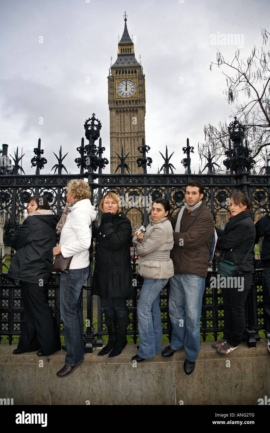 a crowd of people climb railings at the Houses of Parliament in London ...