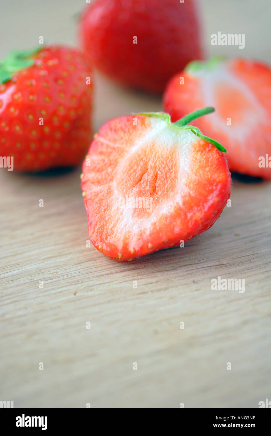 Strawberries cut in half on chopping board Stock Photo - Alamy