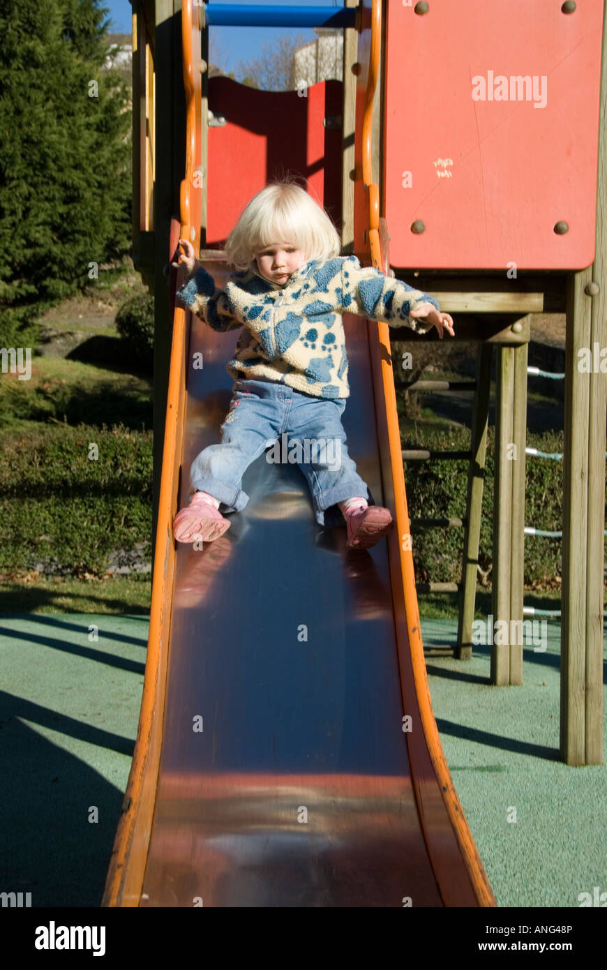 Stock Photo of a 2 year old girl sliding down a slide at the local ...