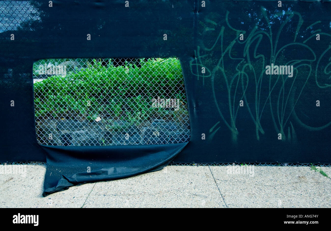 a fence covered with a torn tarp, with green graffiti tags Stock Photo ...