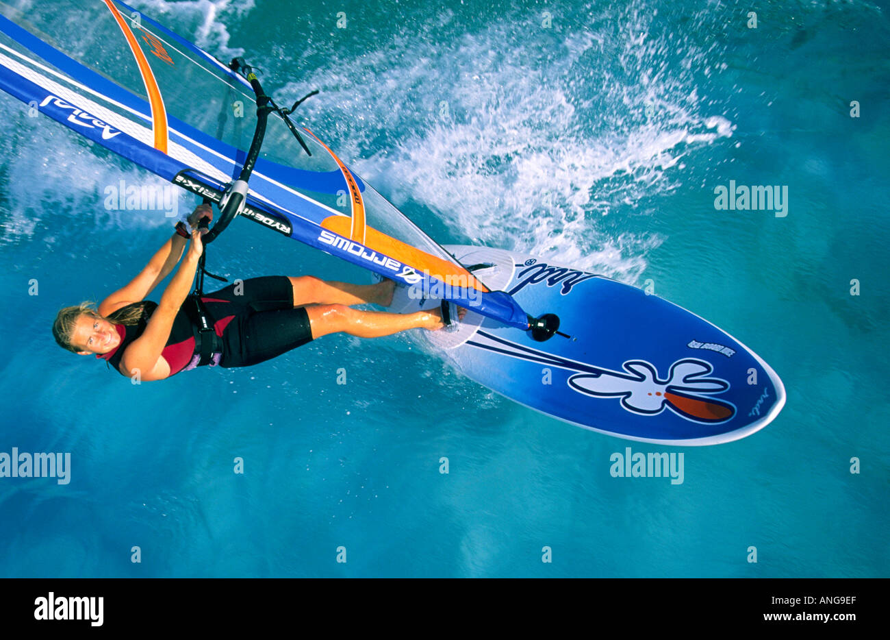 aerial shot of smiling female windsurfer looking at viewer sailing on ...