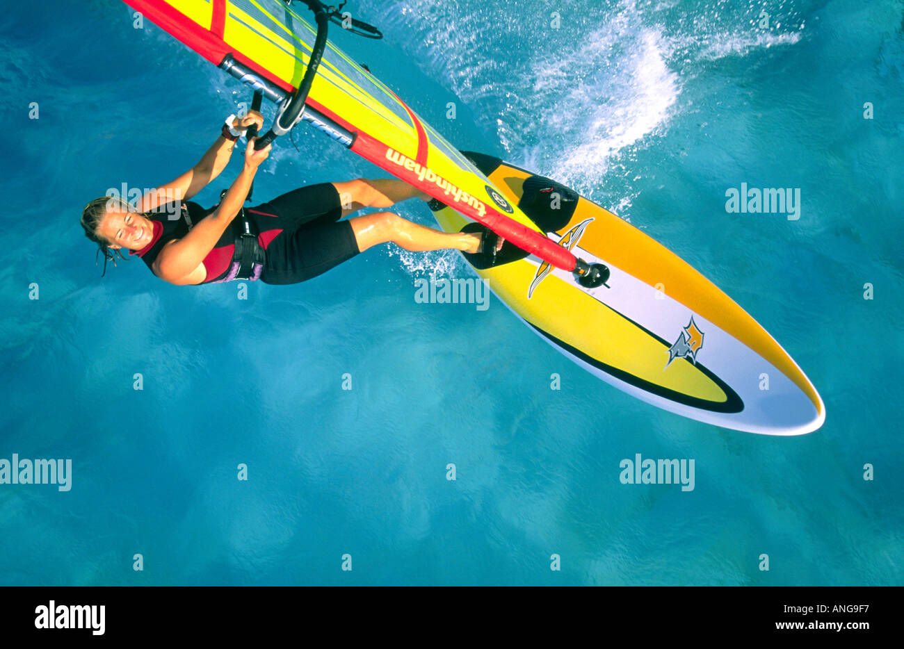 aerial shot of female windsurfer sailing on crystal clear water of Red ...