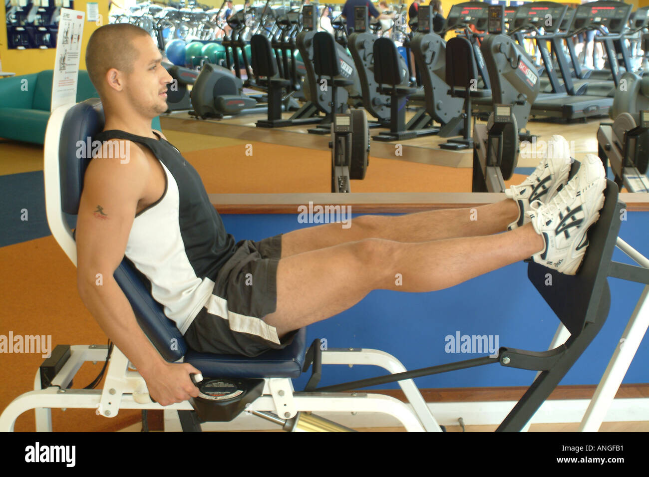 man on leg press machine mid point Stock Photo - Alamy