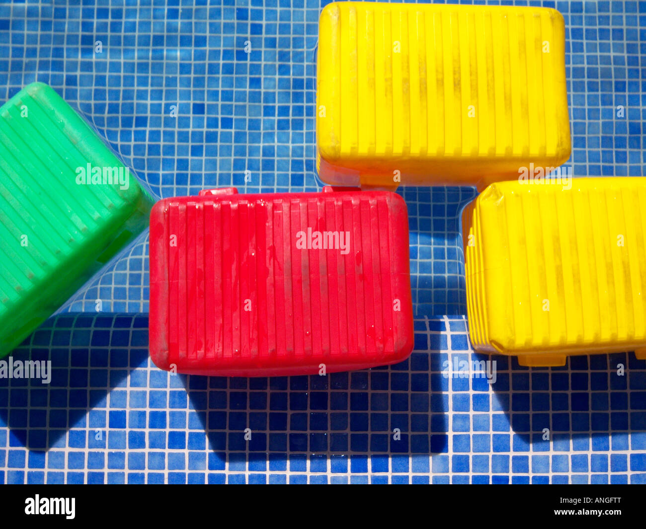 multicolor plastic boxes floating in pool water. Photo by Willy ...