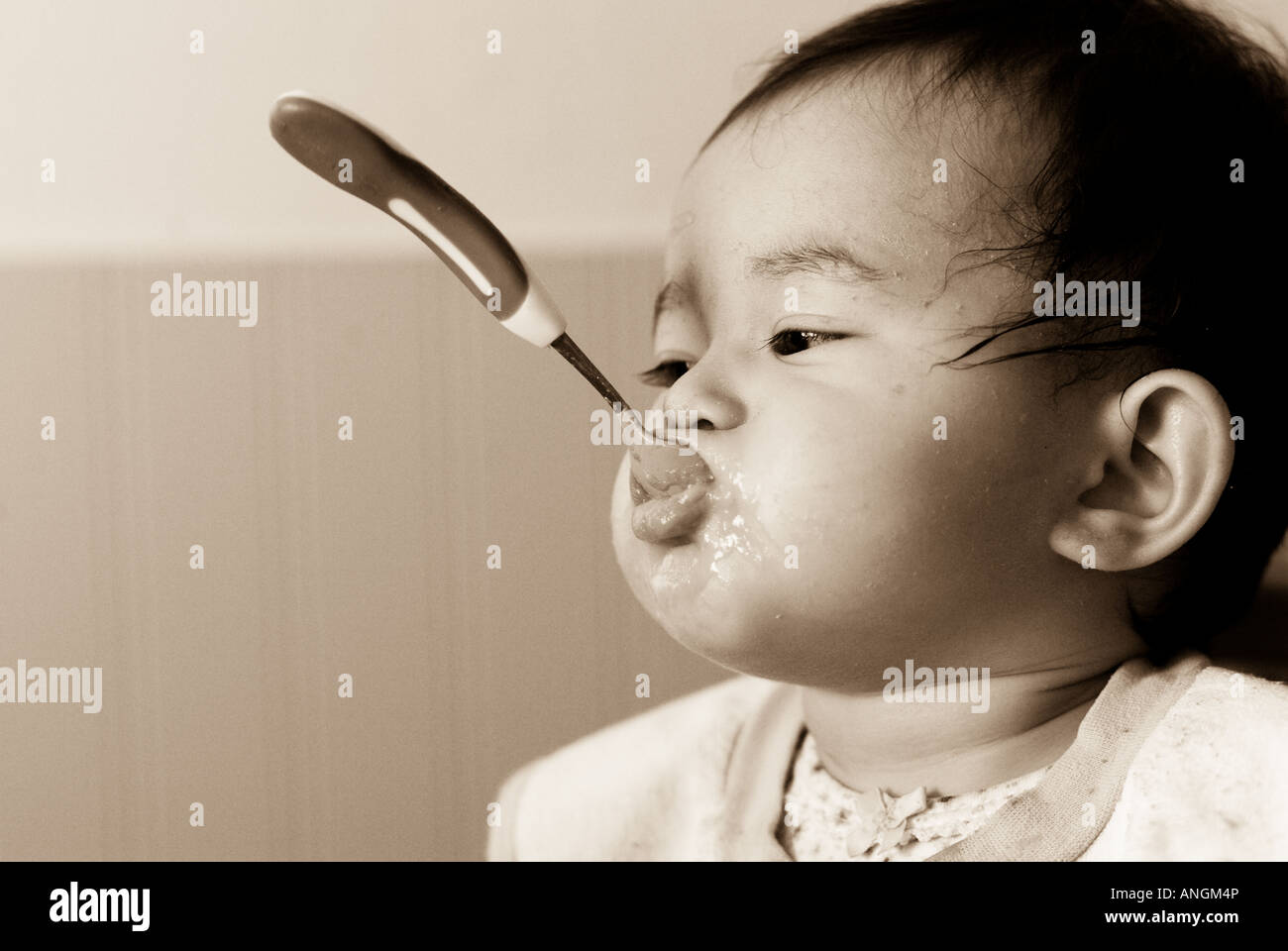 Baby girl with spoon sticking out of her mouth Stock Photo - Alamy