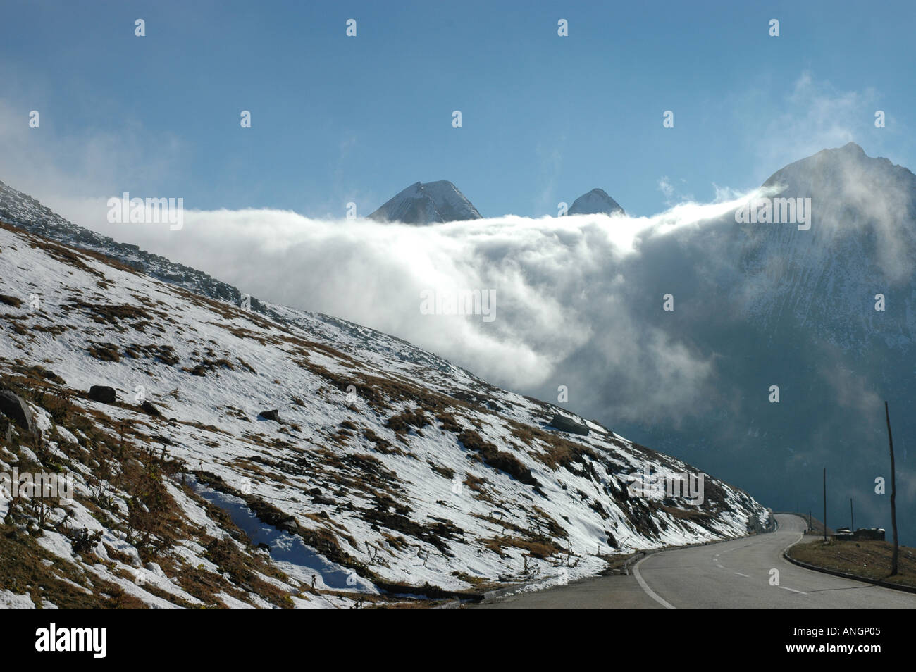 Fog and clouds beeing blown over mountain ridge by Foehn wind Nufenen ...
