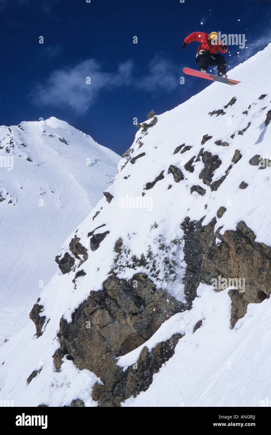 Young male snowboarder flying off large cliff at Lake Louise, Banff ...