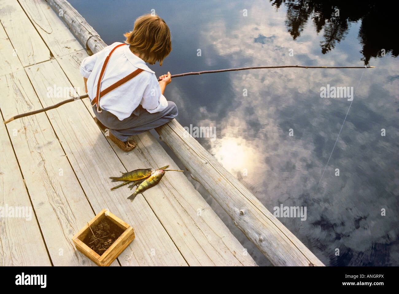 Boy fishing off dock hi-res stock photography and images - Alamy