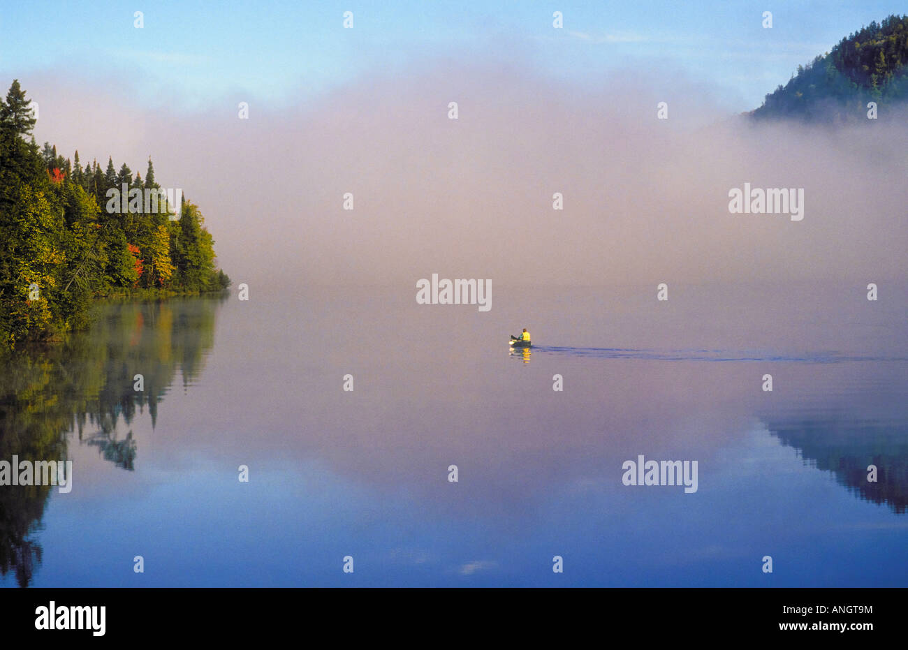 Canoeist paddles through morning mist in early September on Lake Monroe ...