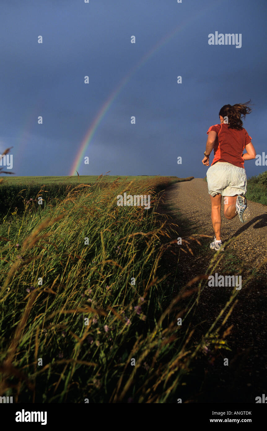 Woman running with rainbow in background hi-res stock photography and ...