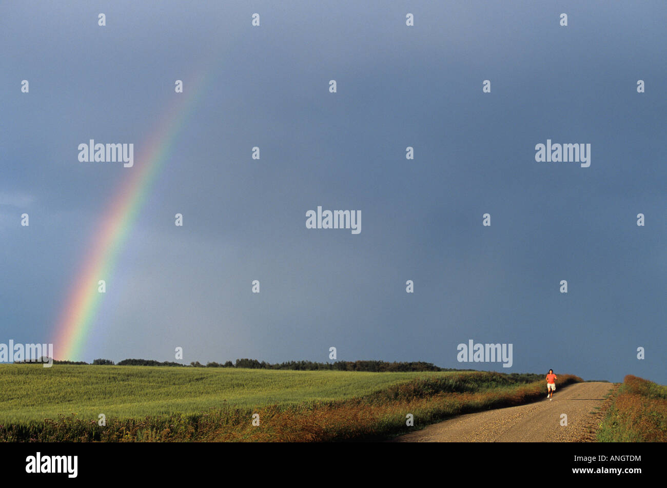 Woman running with rainbow in background hi-res stock photography and ...