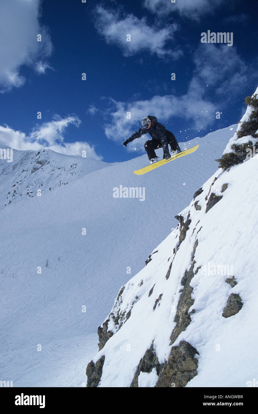 A snowboarder taking off a cliff at Lake Louise Resort, Rocky Mountains ...